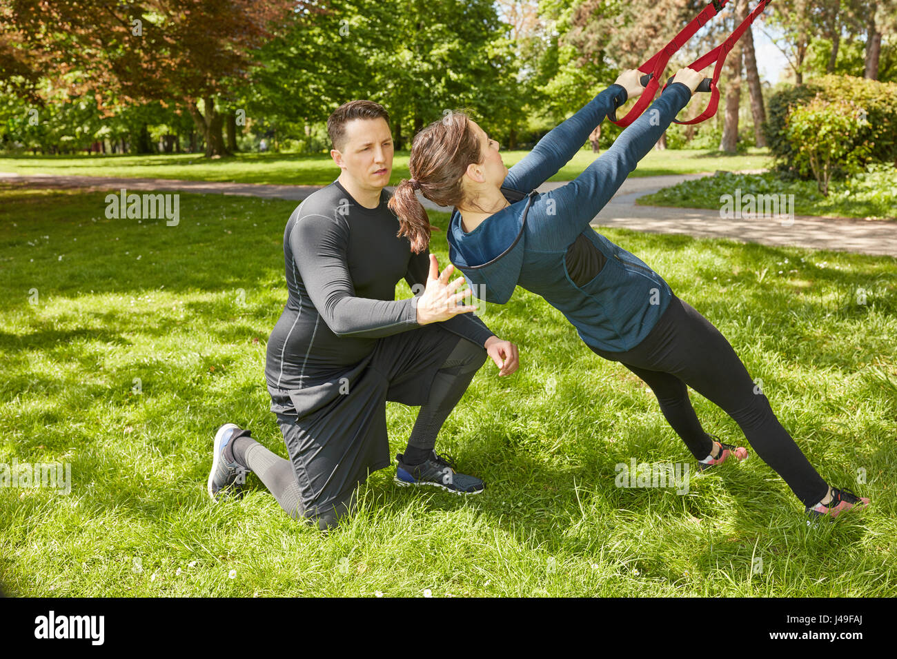 Sporty woman trainer makes exercise hi-res stock photography and images ...
