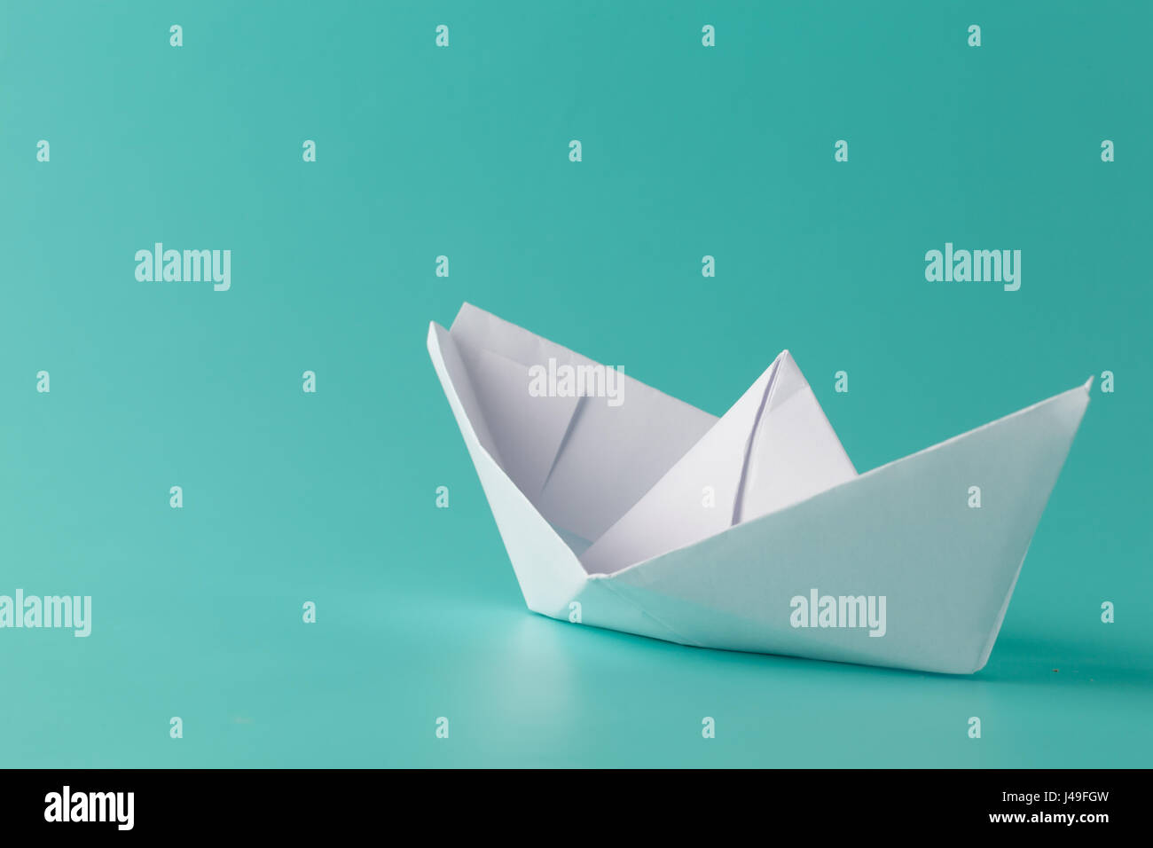 Hand crafted paper boat on aquamarine background Stock Photo - Alamy