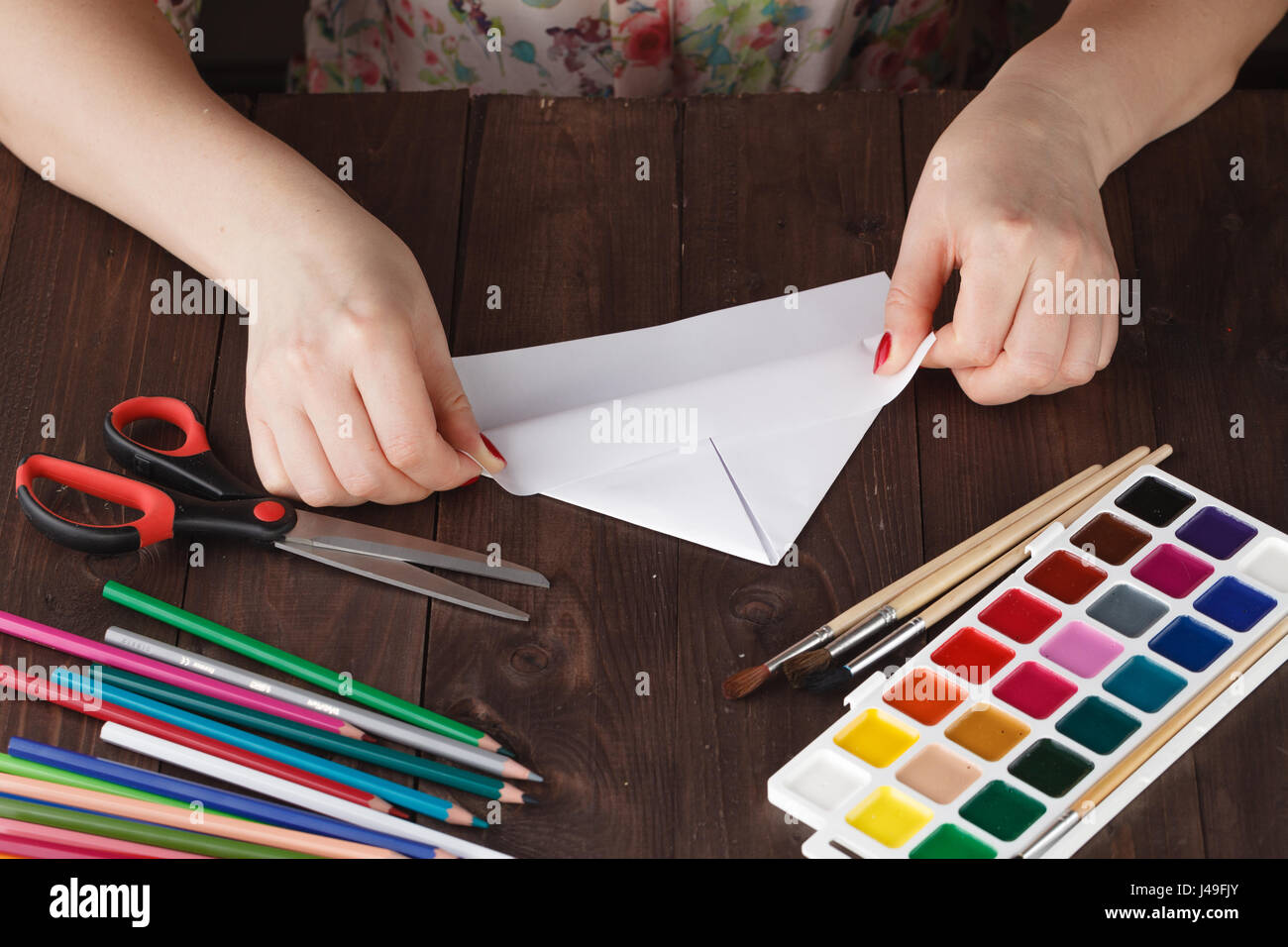 Woman do origami, bend paper sheet for do figure Stock Photo - Alamy