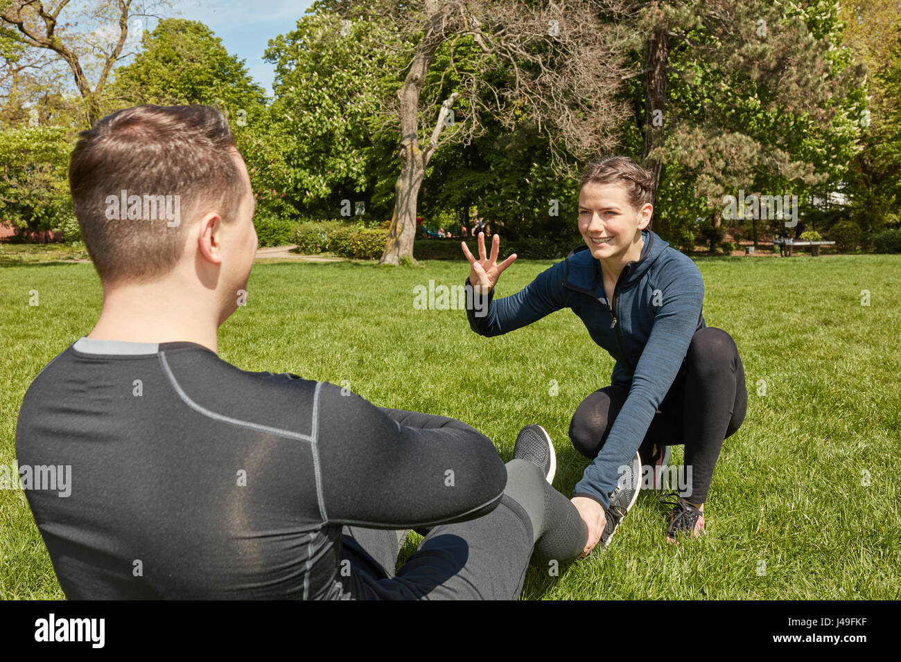 Man makes sit-ups with motivation from Personal Trainer Stock Photo - Alamy