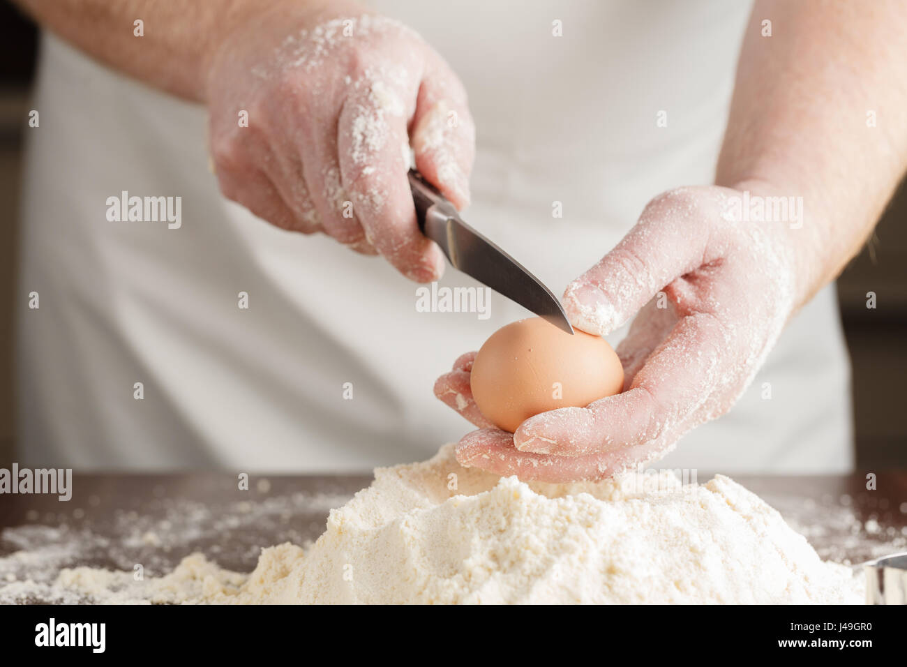 Chef breaking eggs flour hi-res stock photography and images - Alamy