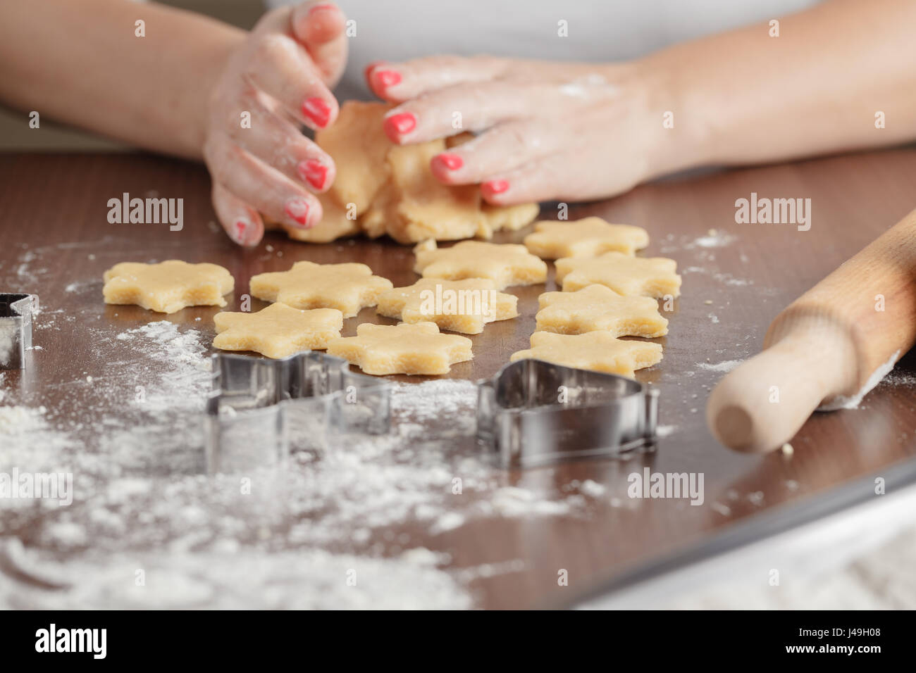 cooking and home concept - close up of female hands making cookies from ...
