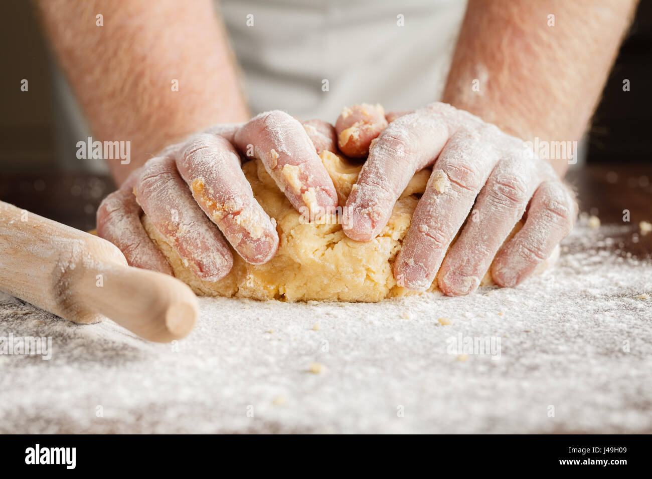 Making dough by men hands on wooden table background Stock Photo - Alamy