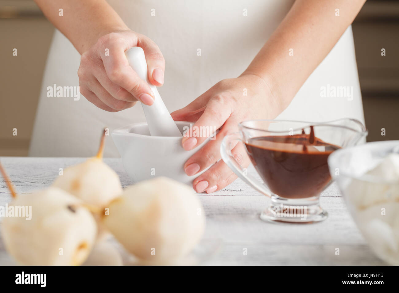 Woman cooking with mortar on white background Stock Photo - Alamy