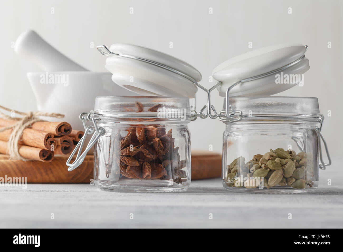 spices in glass jars on rustic wooden table Stock Photo - Alamy