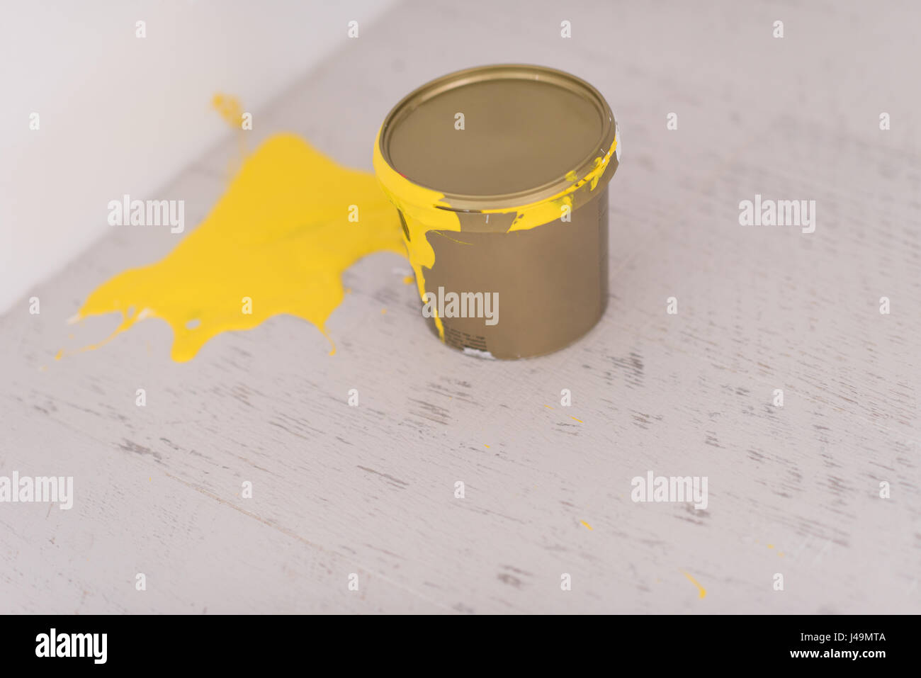 Yellow paint tin can with yellow strokes on the wooden floor Stock ...