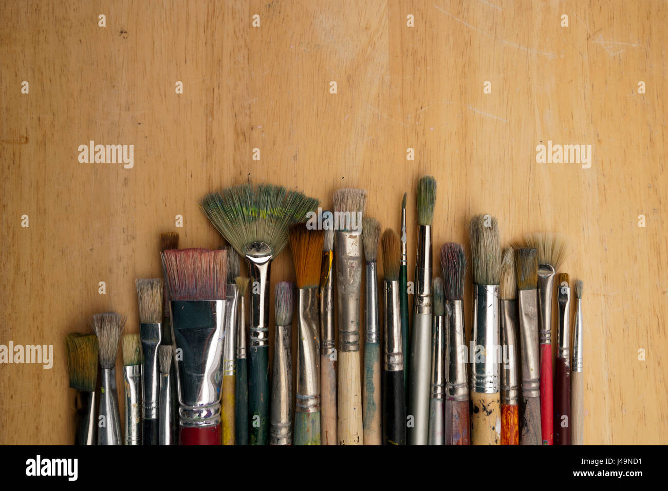 A collection of well used art paint brushes on wood Stock Photo - Alamy