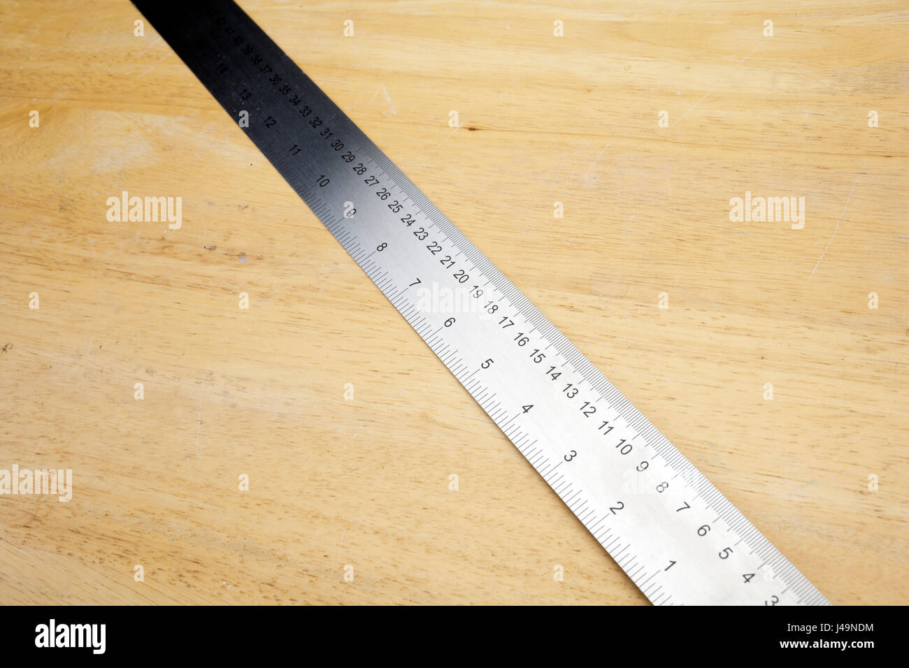 A shiny new steel rule on wood with copy space Stock Photo - Alamy