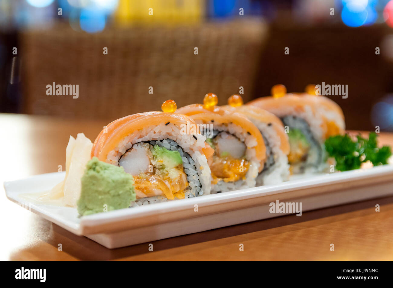 A delicious salmon sushi roll with large roe, served with wasabi ...