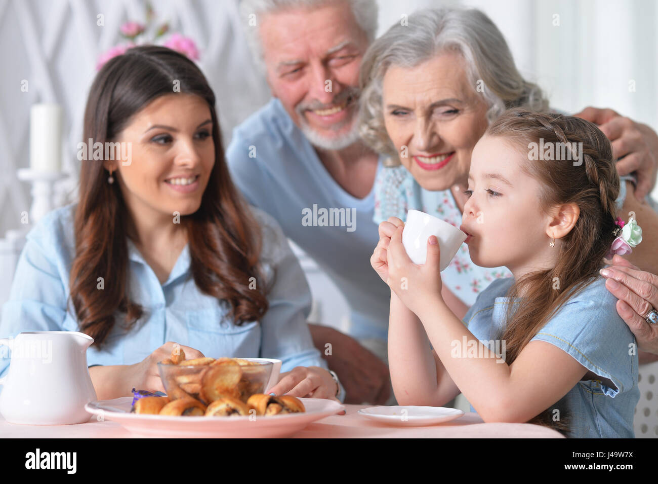 Beautiful happy family drinking tea Stock Photo - Alamy