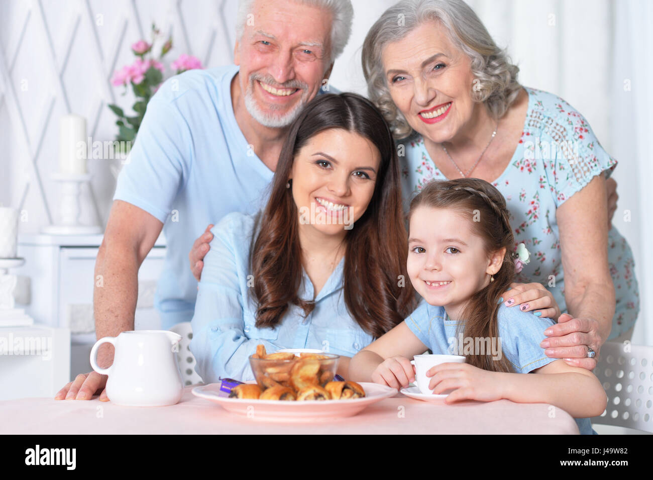 Beautiful happy family drinking tea Stock Photo - Alamy