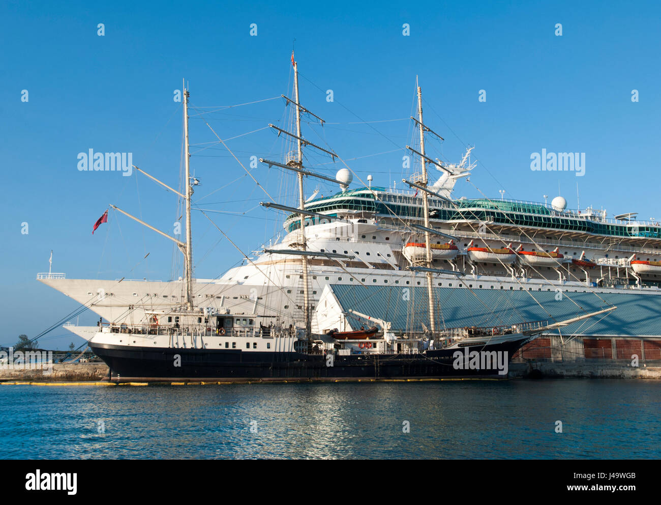 The view of an old style ship with a cruise liner behind in Nassau city ...