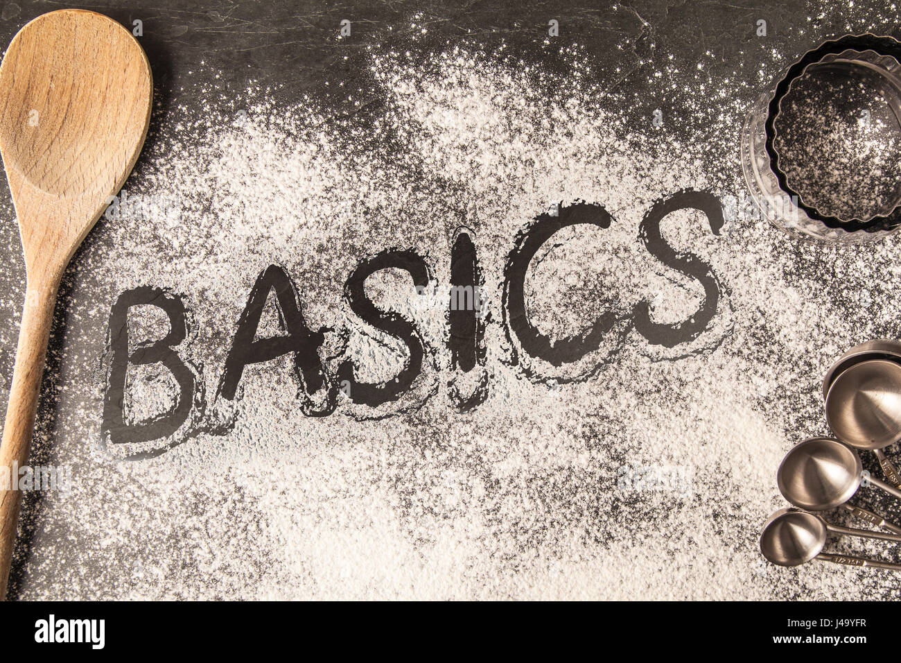 Handwritten word drawn in the flour - basics Stock Photo - Alamy