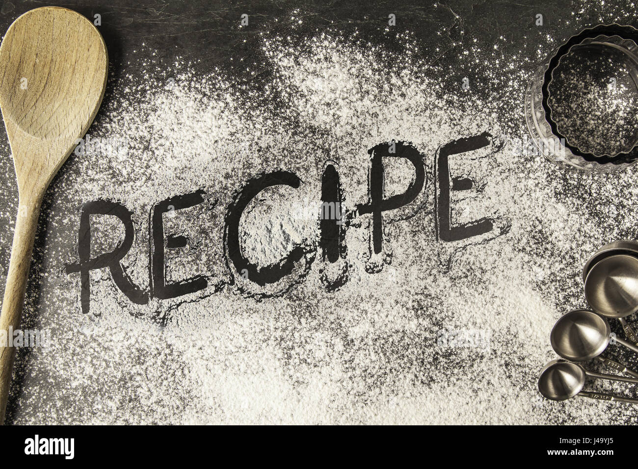 Handwritten word drawn in the flour - Recipe Stock Photo - Alamy