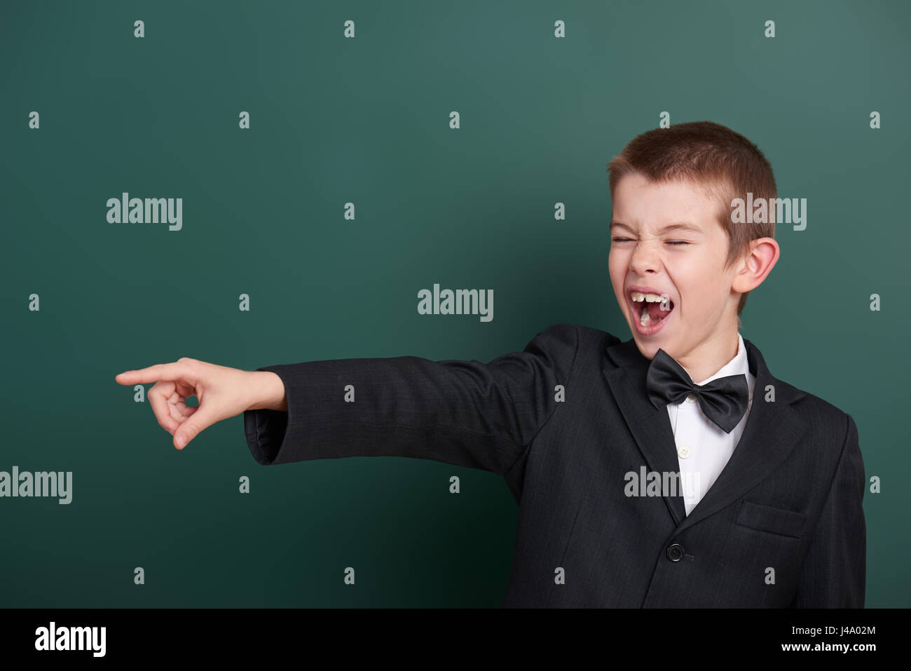 school boy point the finger near blank chalkboard background, dressed ...