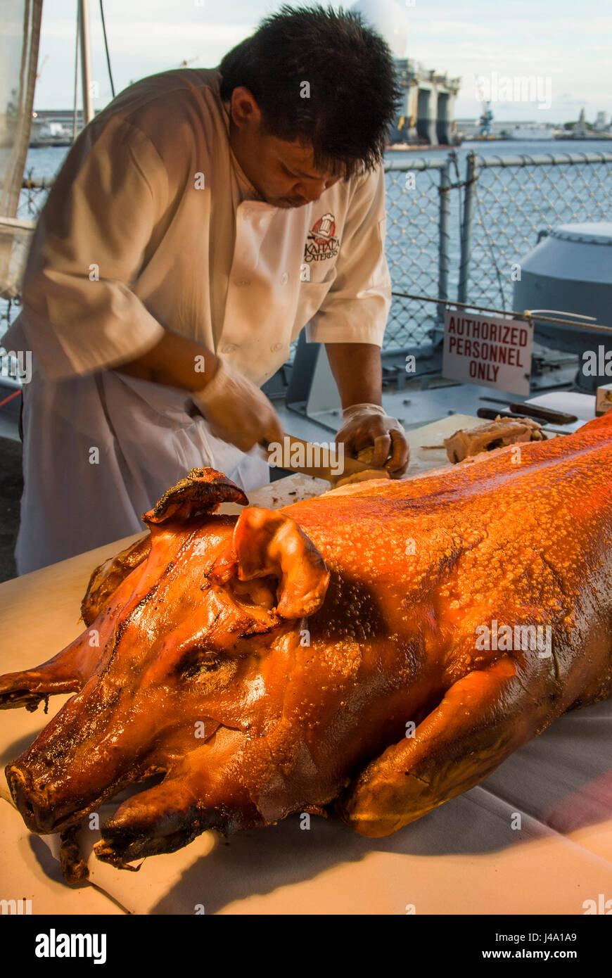 Chef carves cooked pig for dinner, USS Missouri, Pearl Harbor, Honolulu ...