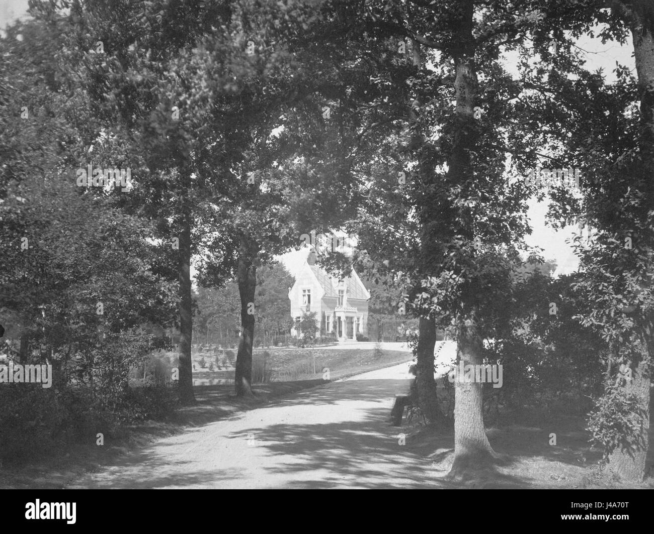 This image shows a picturesque road leading to a stone cottage ...