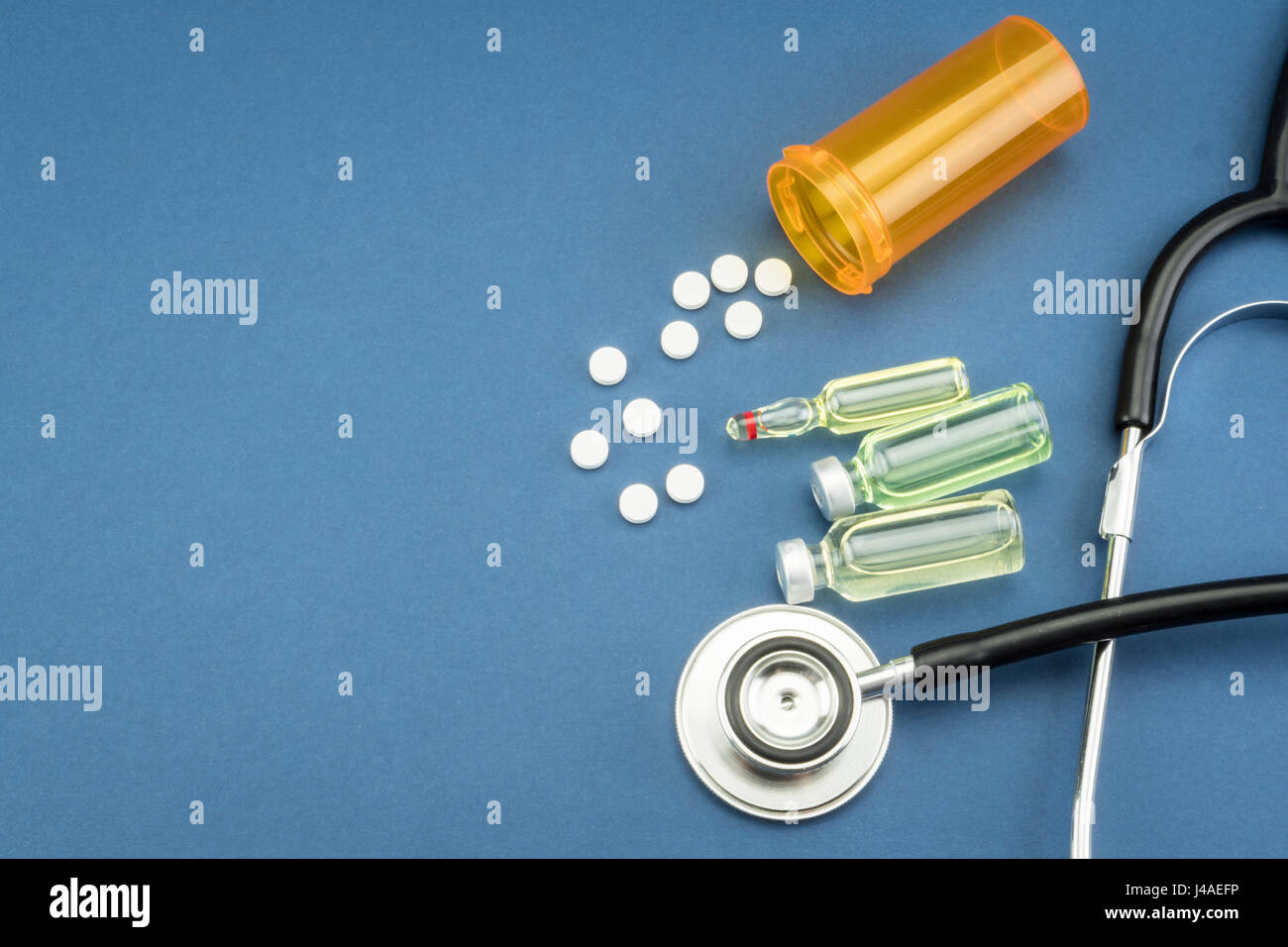 stethoscope, pills, vials in medical room on blue background top view ...