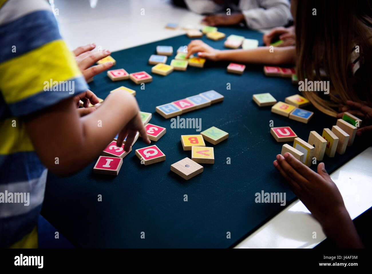 Kindergarten kids playing wooden alphabets letters vocabulary game ...
