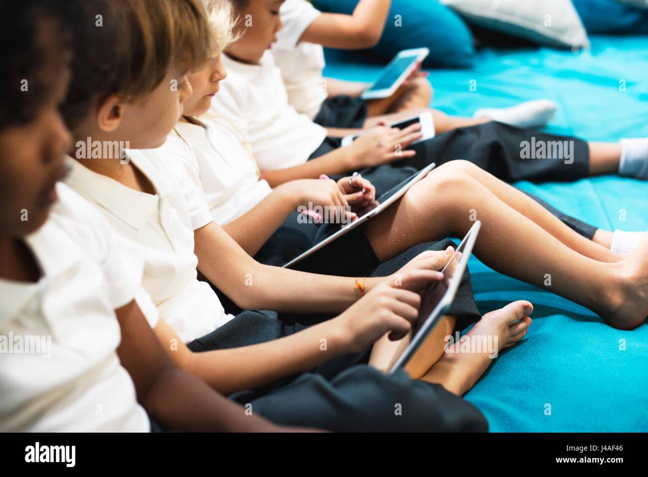 Group of diverse kindergarten students using digital devices Stock ...