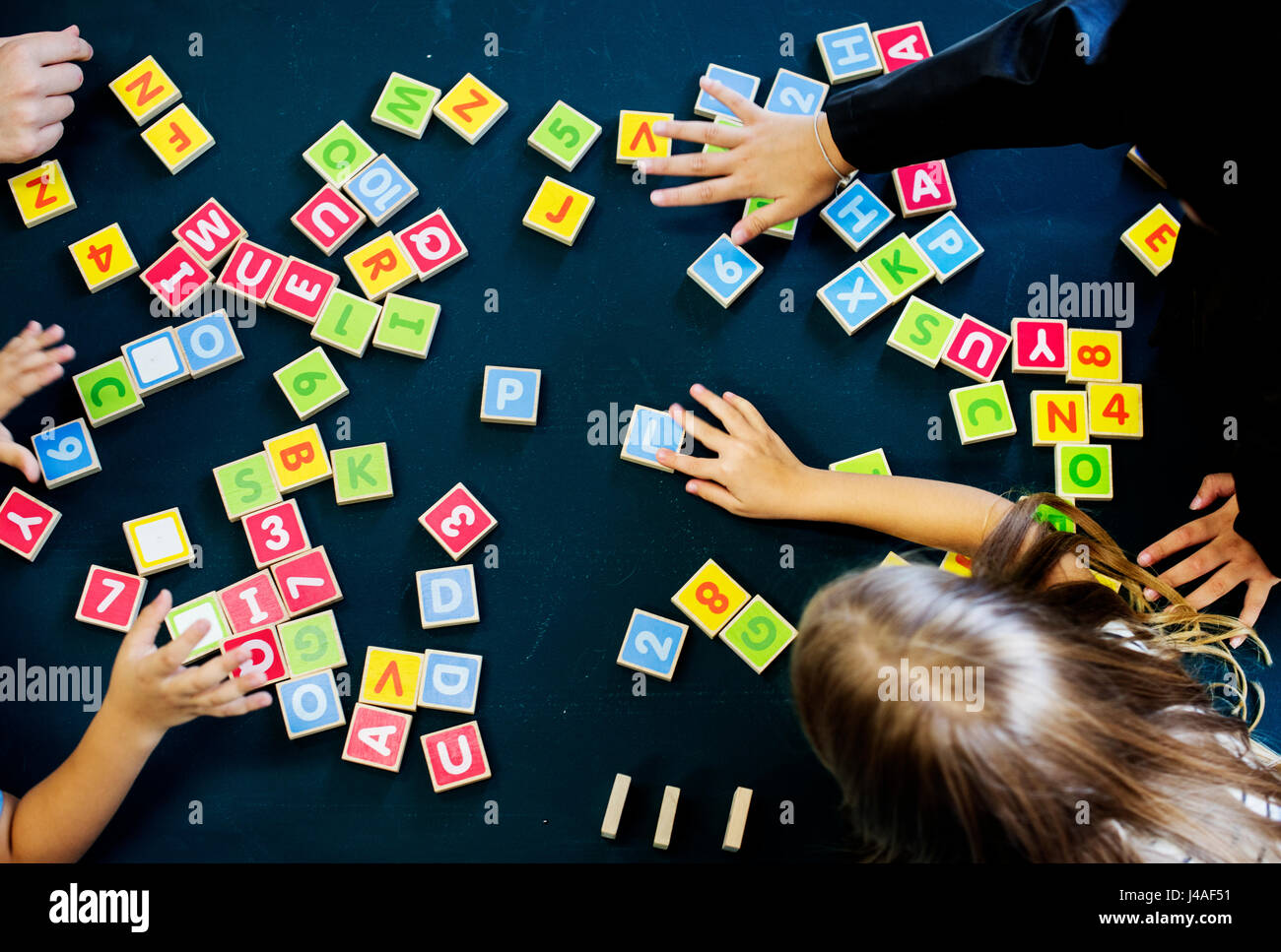 Kindergarten kids playing wooden alphabets letters vocabulary game ...