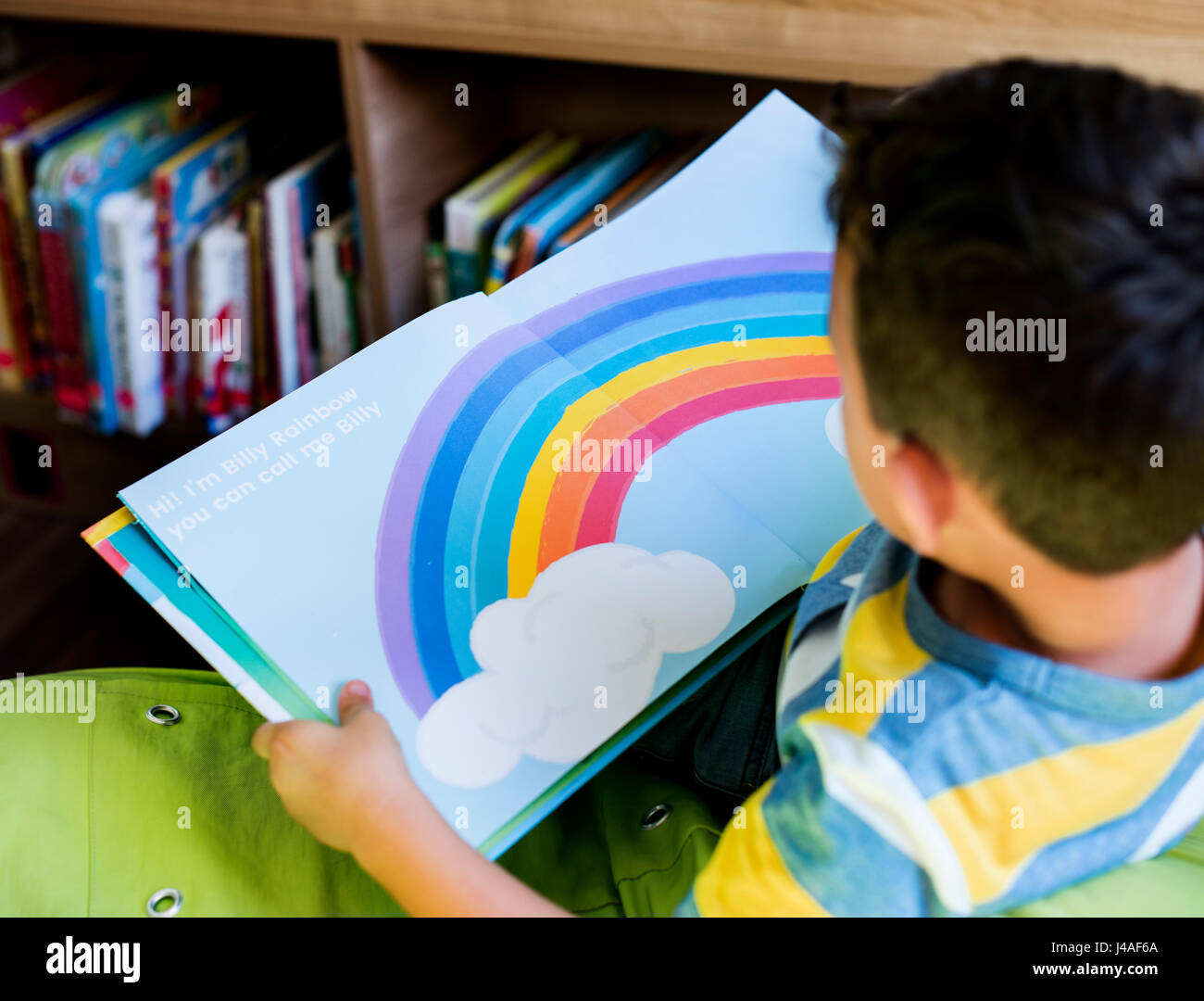 Young Boy Reading Children Story Book in Library Stock Photo - Alamy