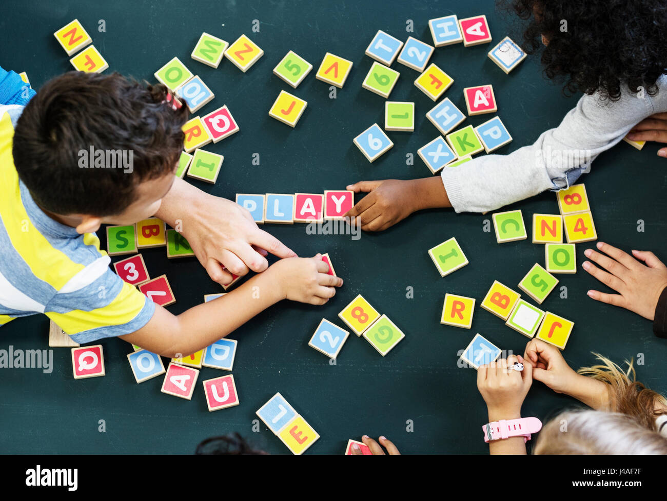 Kindergarten kids playing wooden alphabets letters vocabulary game ...