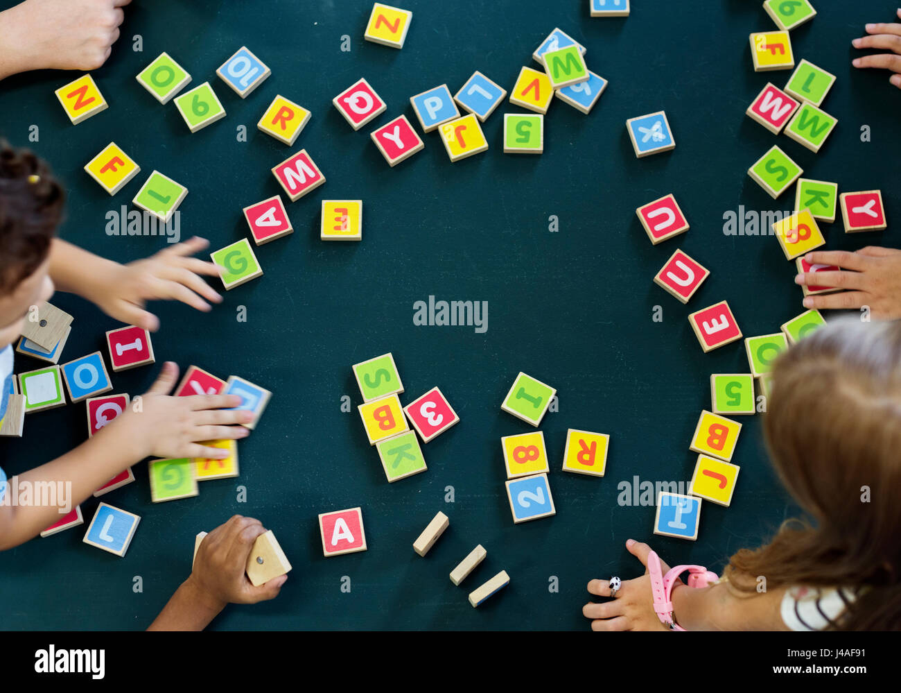 Kindergarten kids playing wooden alphabets letters vocabulary game ...