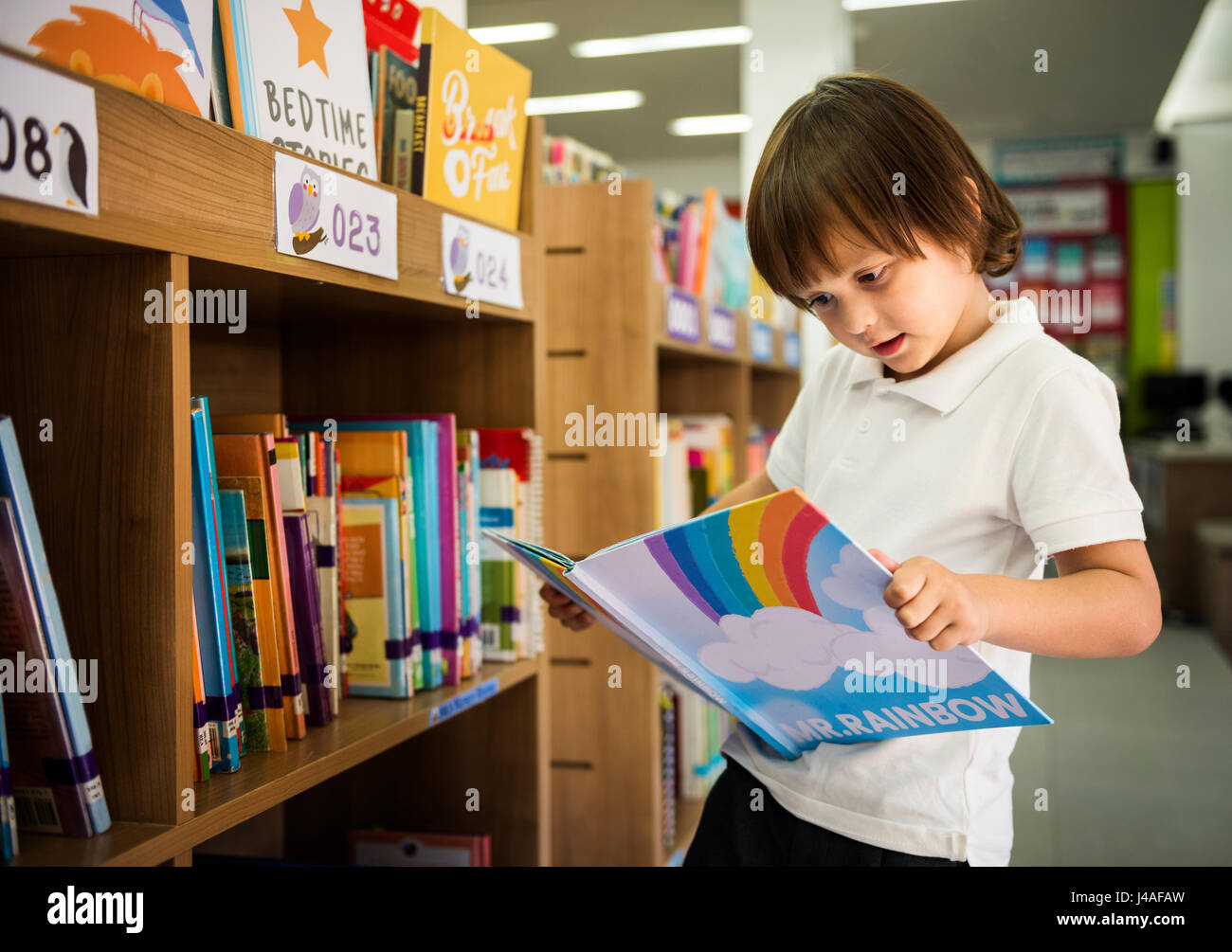 Young Boy Reading Children Story Book in Library Stock Photo - Alamy