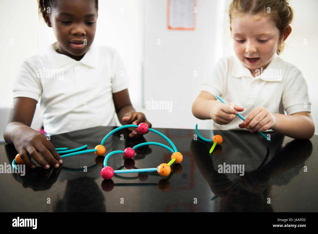 Diverse kindergarten students holding learning structures from toys ...