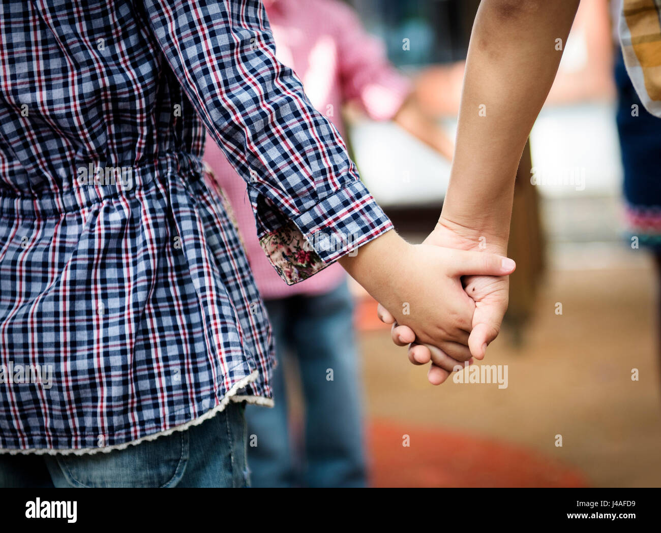 Group of diverse kindergarten students standing holding hands together ...