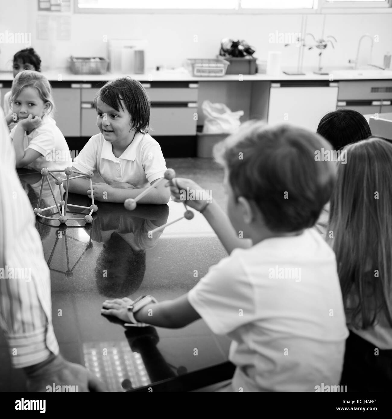 Diverse kindergarten students holding learning structures from toys ...