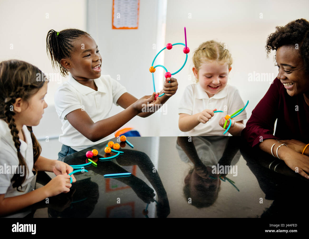 Diverse kindergarten students holding learning structures from toys ...