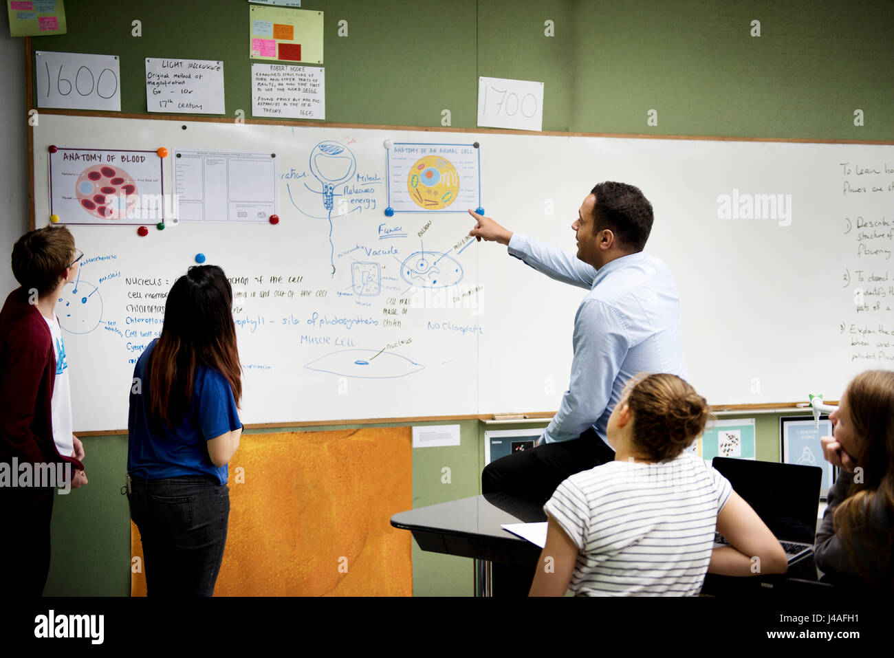 Group of students learning in classroom Stock Photo - Alamy