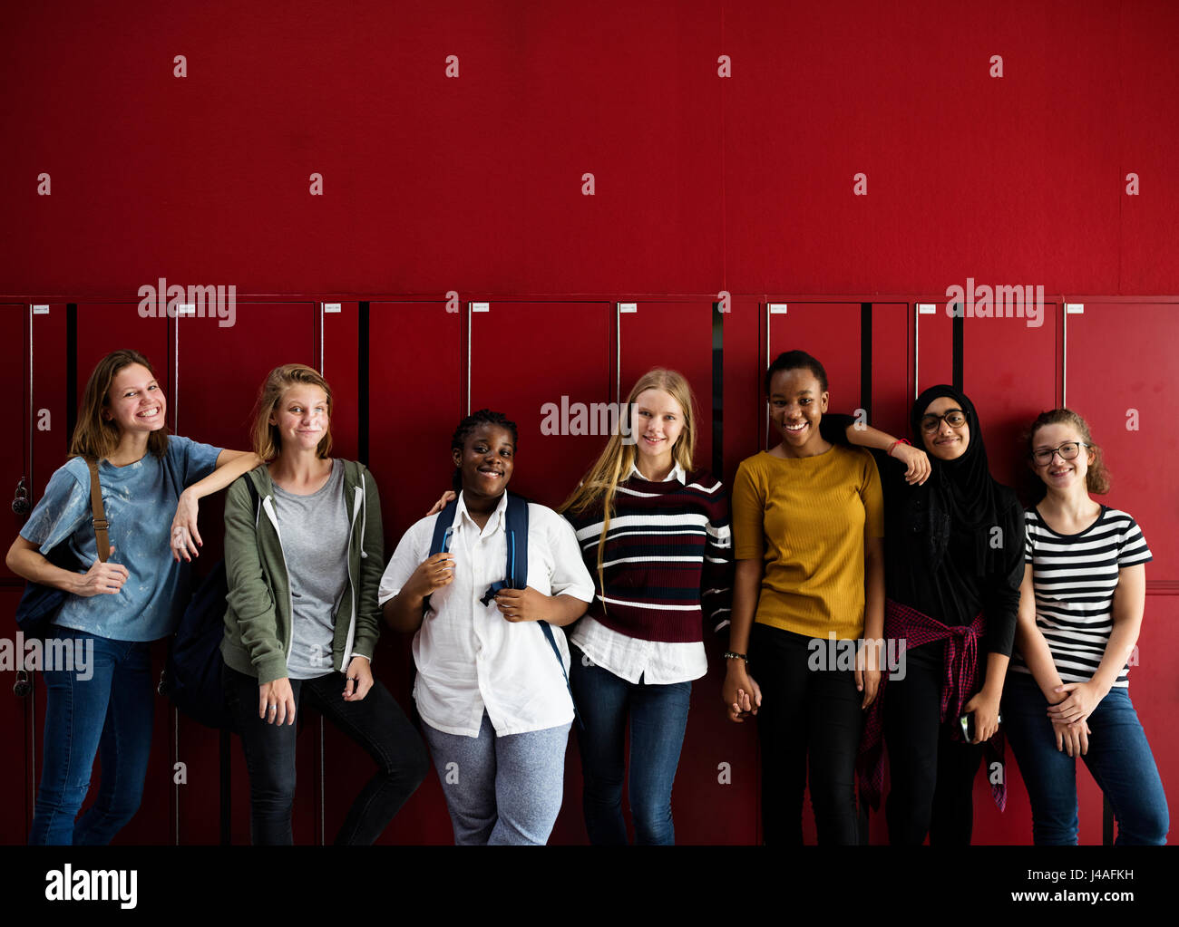 Friends standing together in front of lockers Stock Photo - Alamy