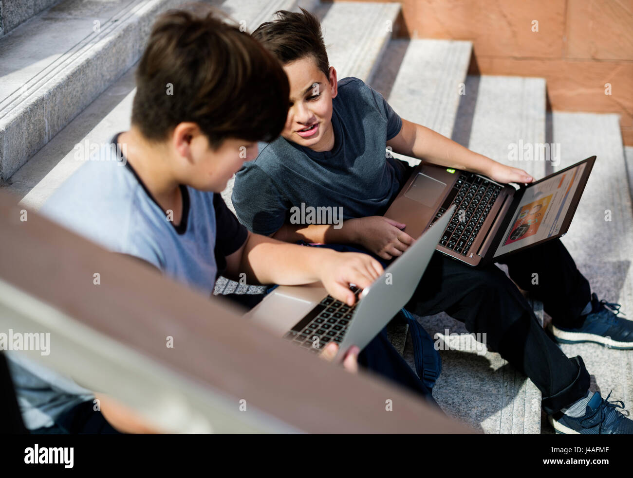 Group of students sitting on staircase using lptop Stock Photo - Alamy