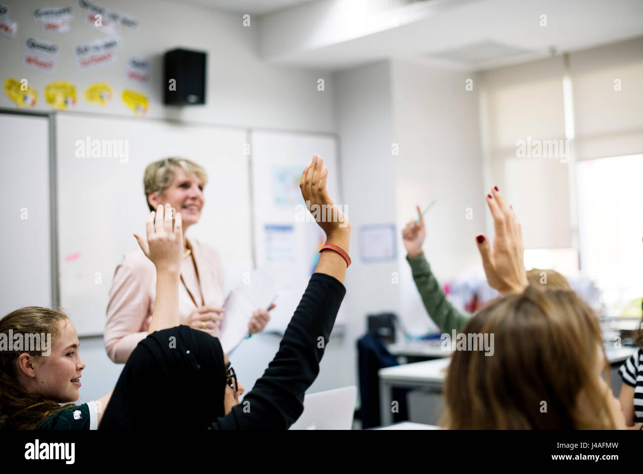 Group of student learning arms raised Stock Photo - Alamy