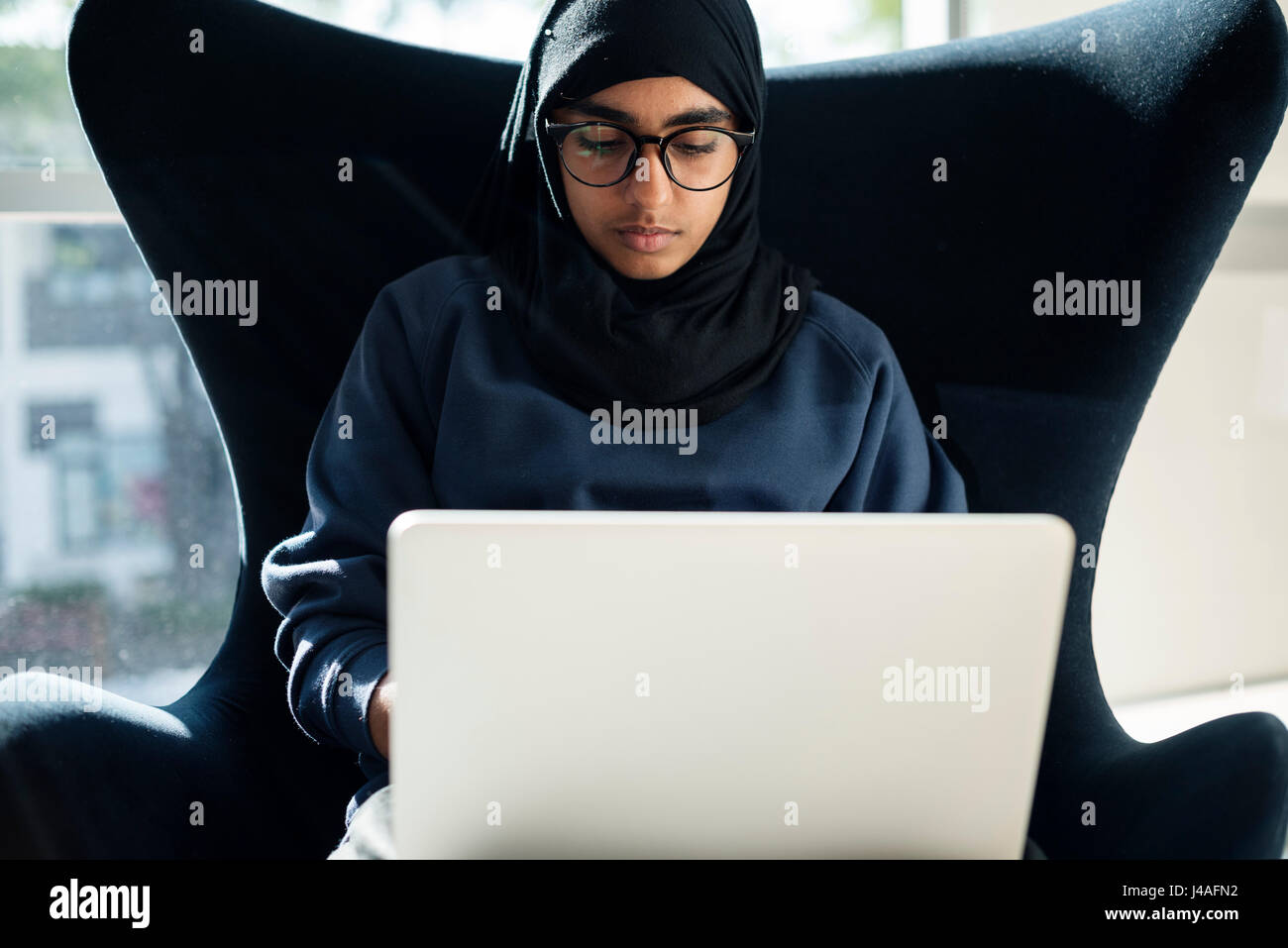 Islamic girl sitting and using laptop Stock Photo - Alamy