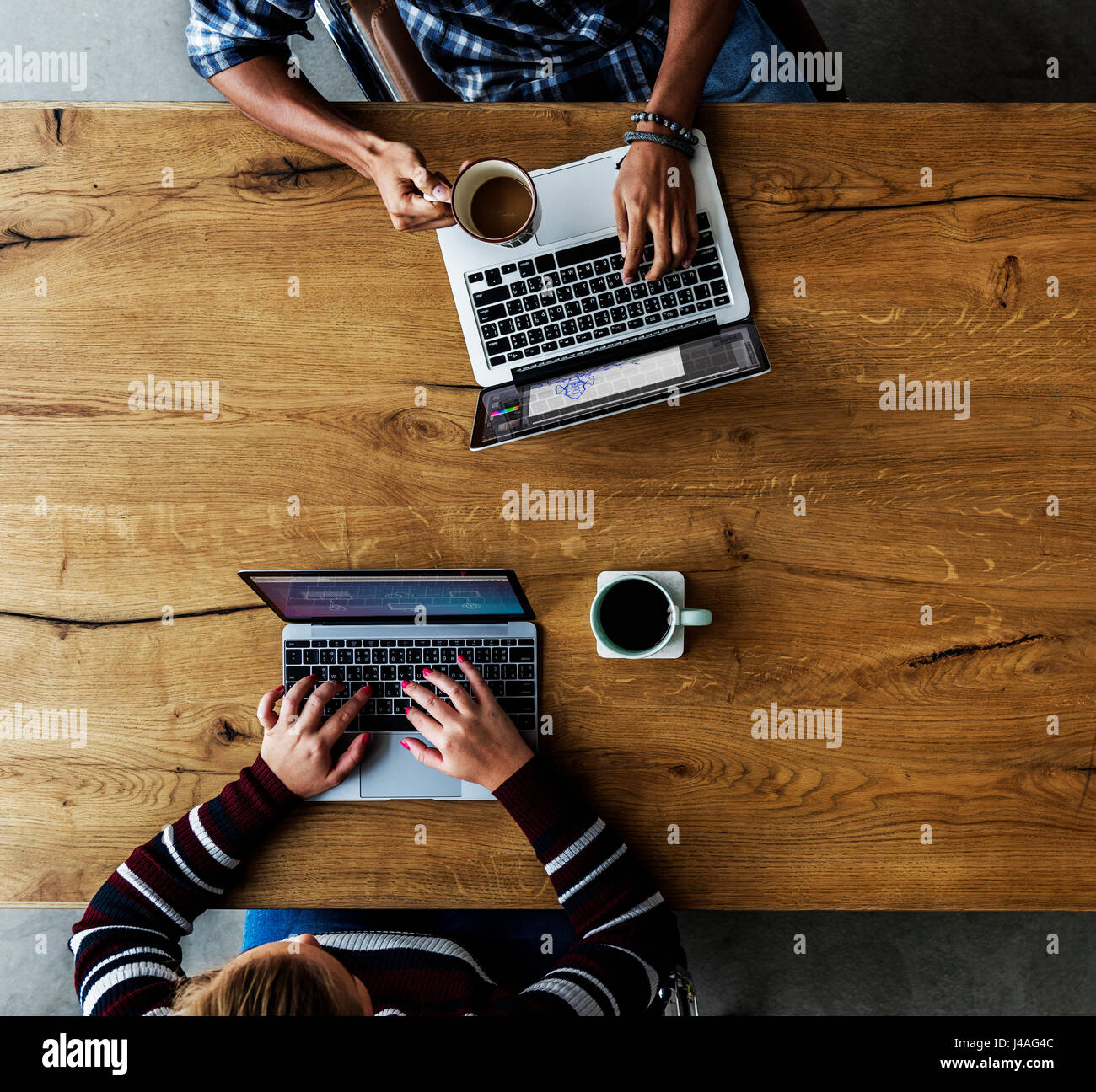 Colleagues Sitting Together Working on Laptop Stock Photo - Alamy