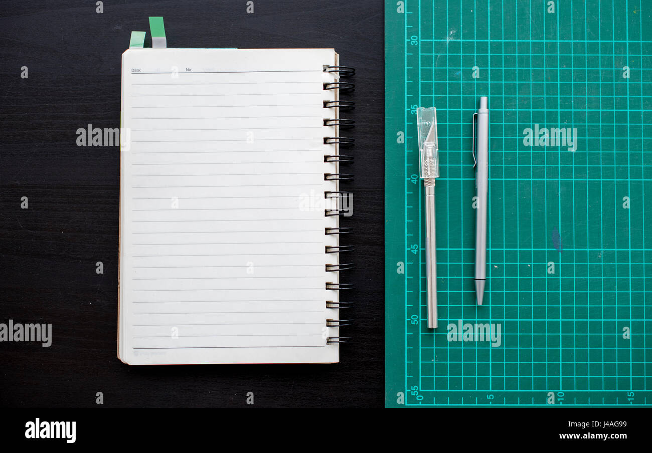 Open notebook with cutting board stationery on dark gray table Stock ...
