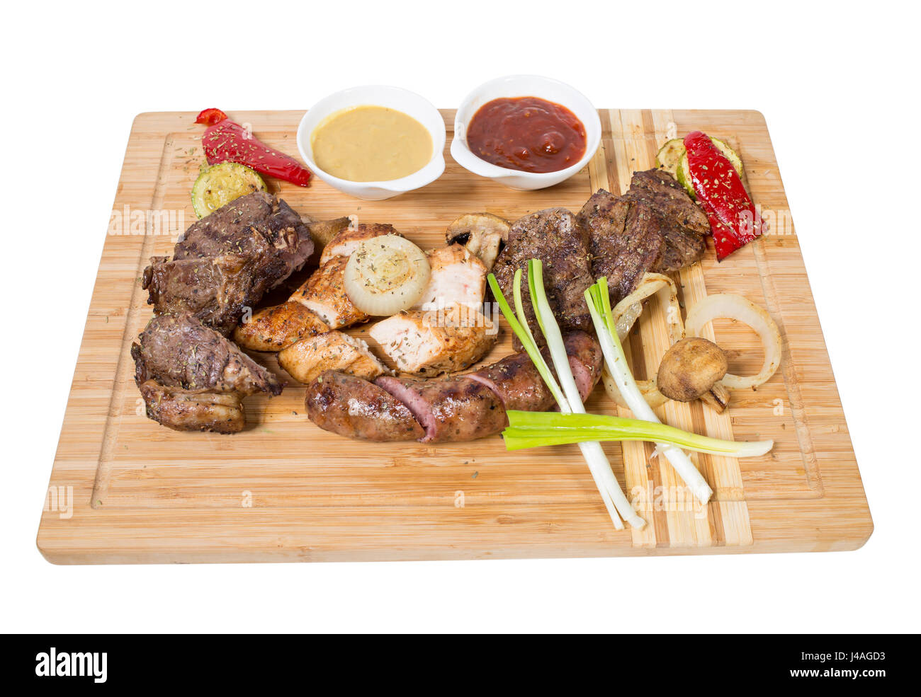 Mixed grilled meats platter with vegetables and sauces. Isolated on a ...