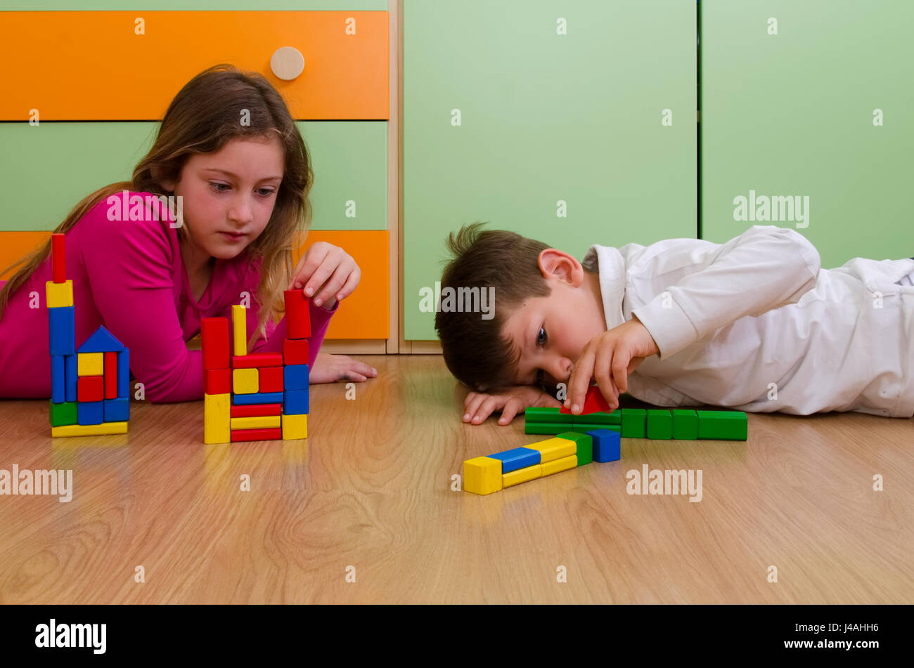 Children playing with construction toy blocks on floor of house Stock ...