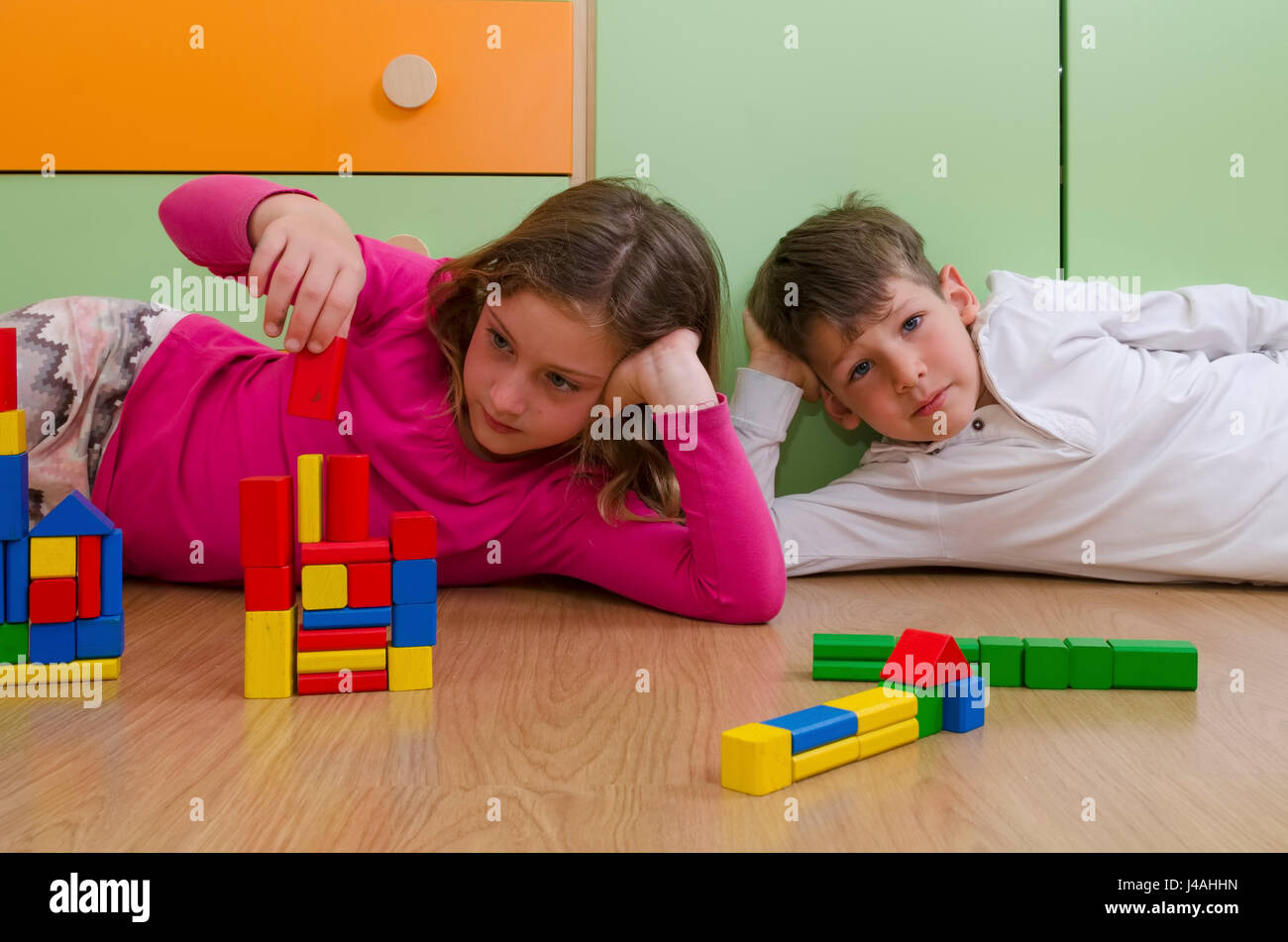 Children playing with construction toy blocks on floor of house Stock ...