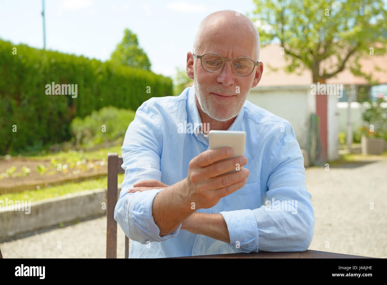 a senior man using the mobile phone outside Stock Photo - Alamy