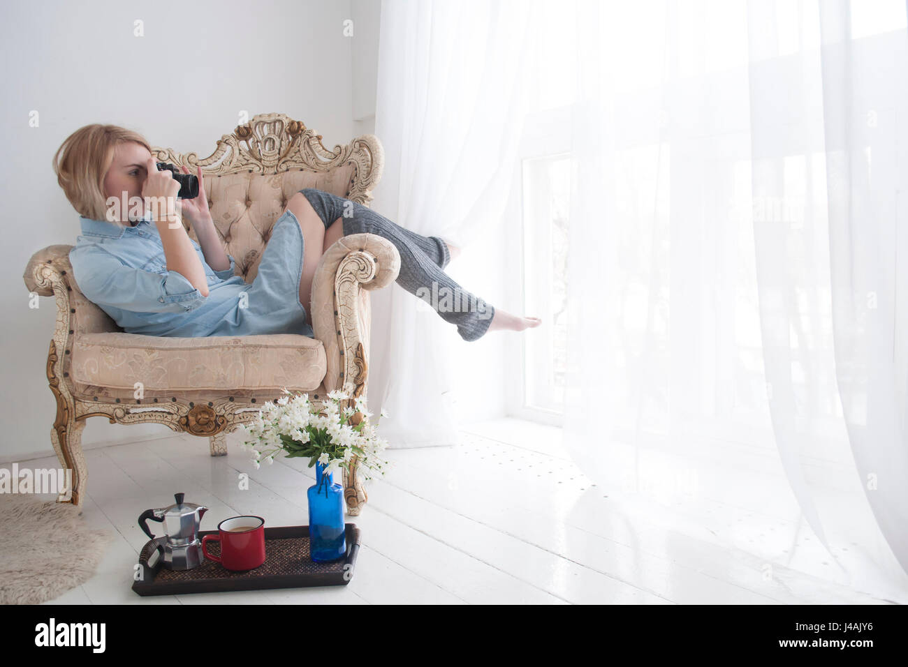 Pretty young woman taking a photo through the window Stock Photo - Alamy