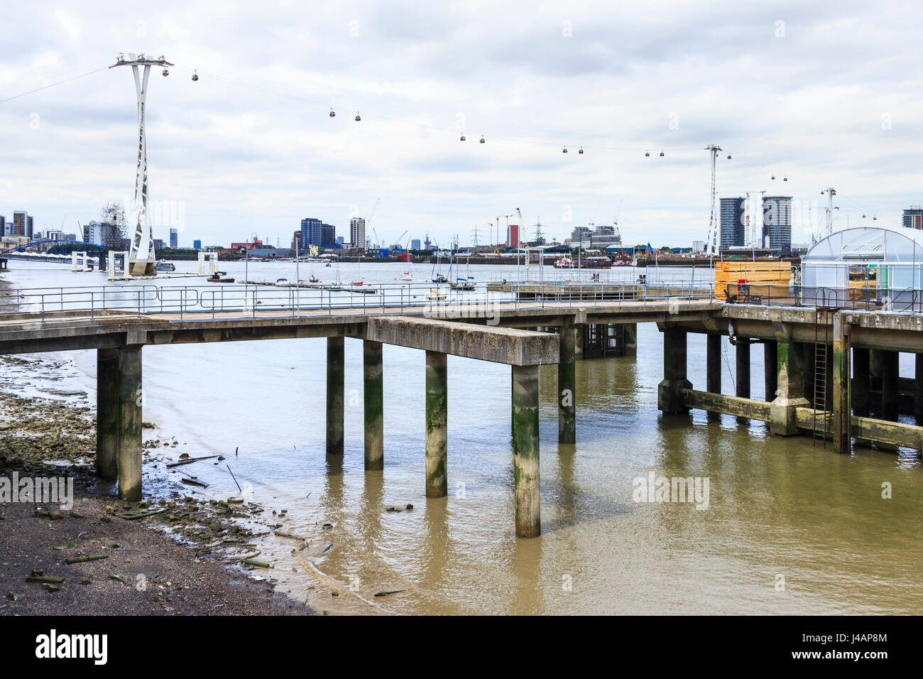 A wooden jetty or pier on the River Thames at North Greenwich, London ...