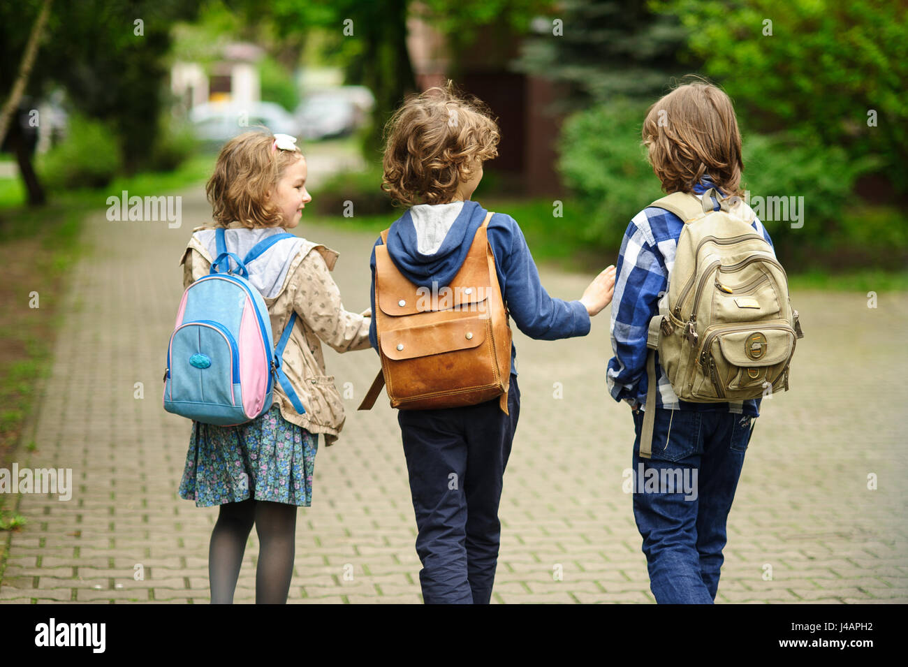 Little school students hurry on occupations. Behind shoulders at ...
