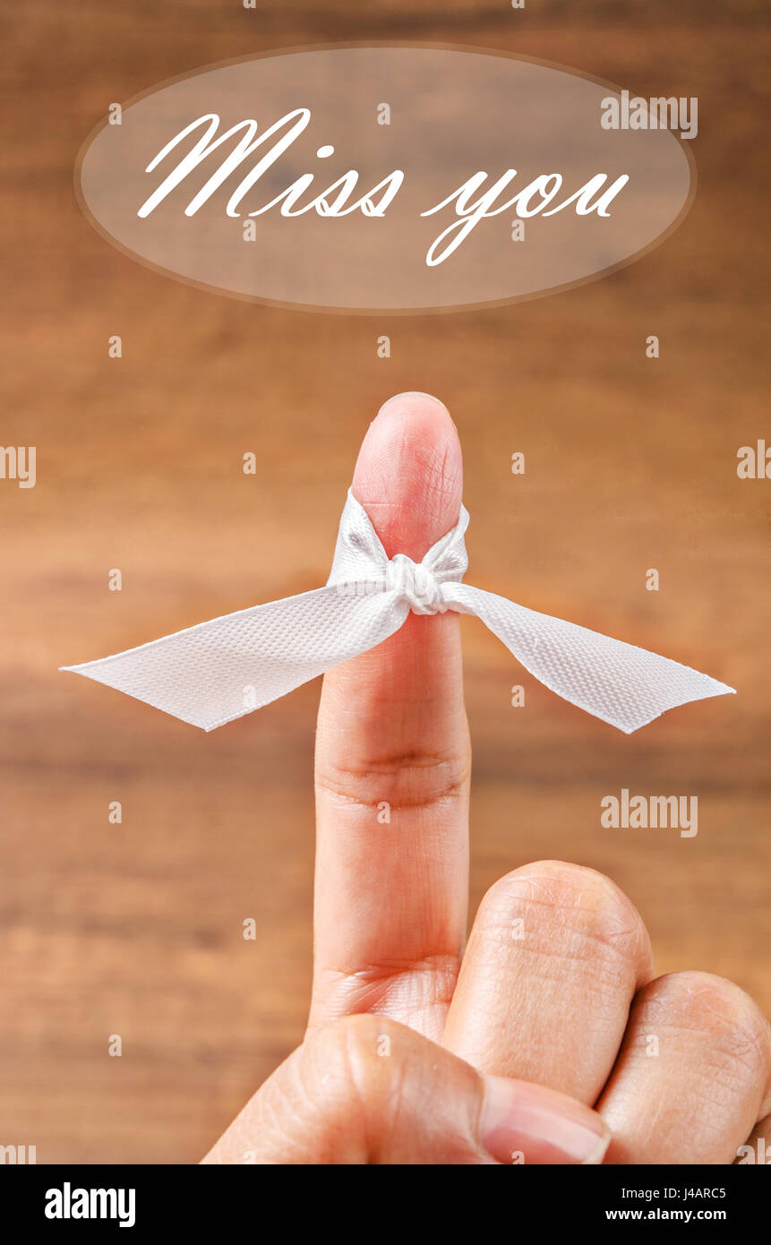 Hand with white ribbon and Miss you text on wooden background Stock ...