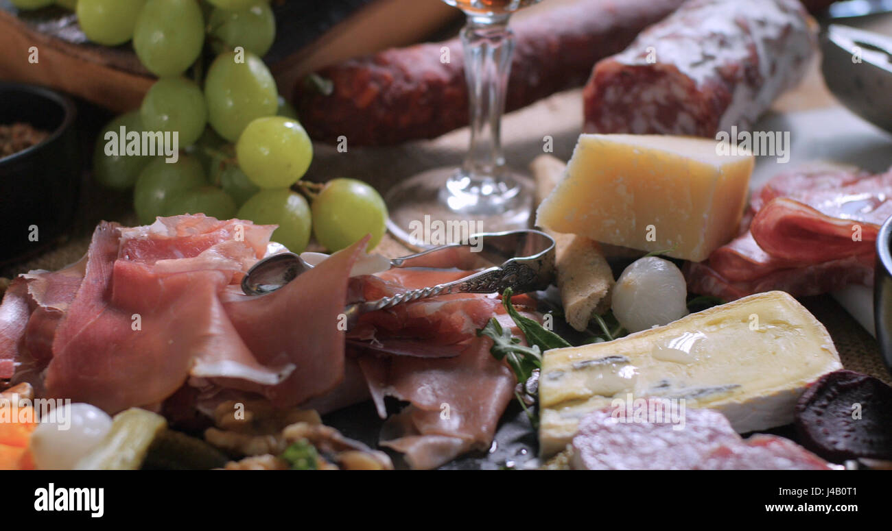 close up view of a platter of cured meat (charcuterie): ham, salami and ...