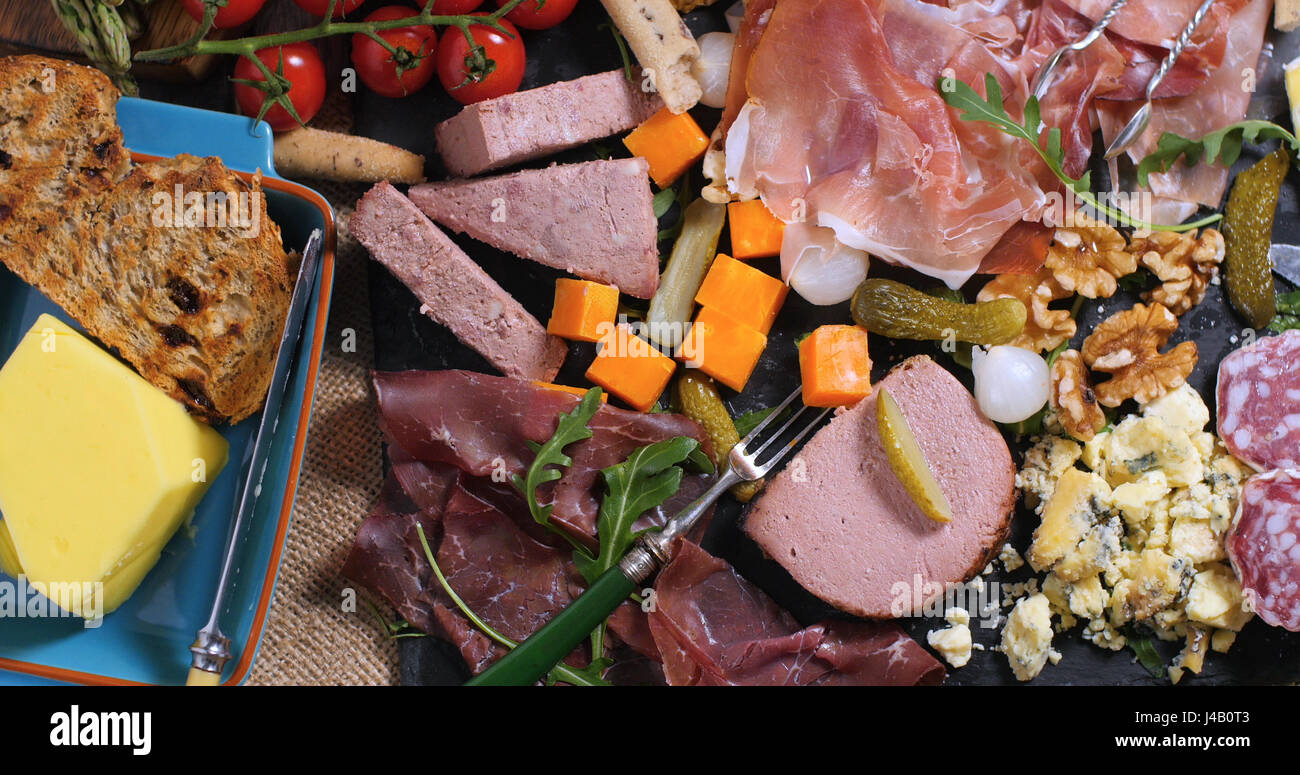 Top down view of a platter of cured meat (charcuterie), ham, salami ...